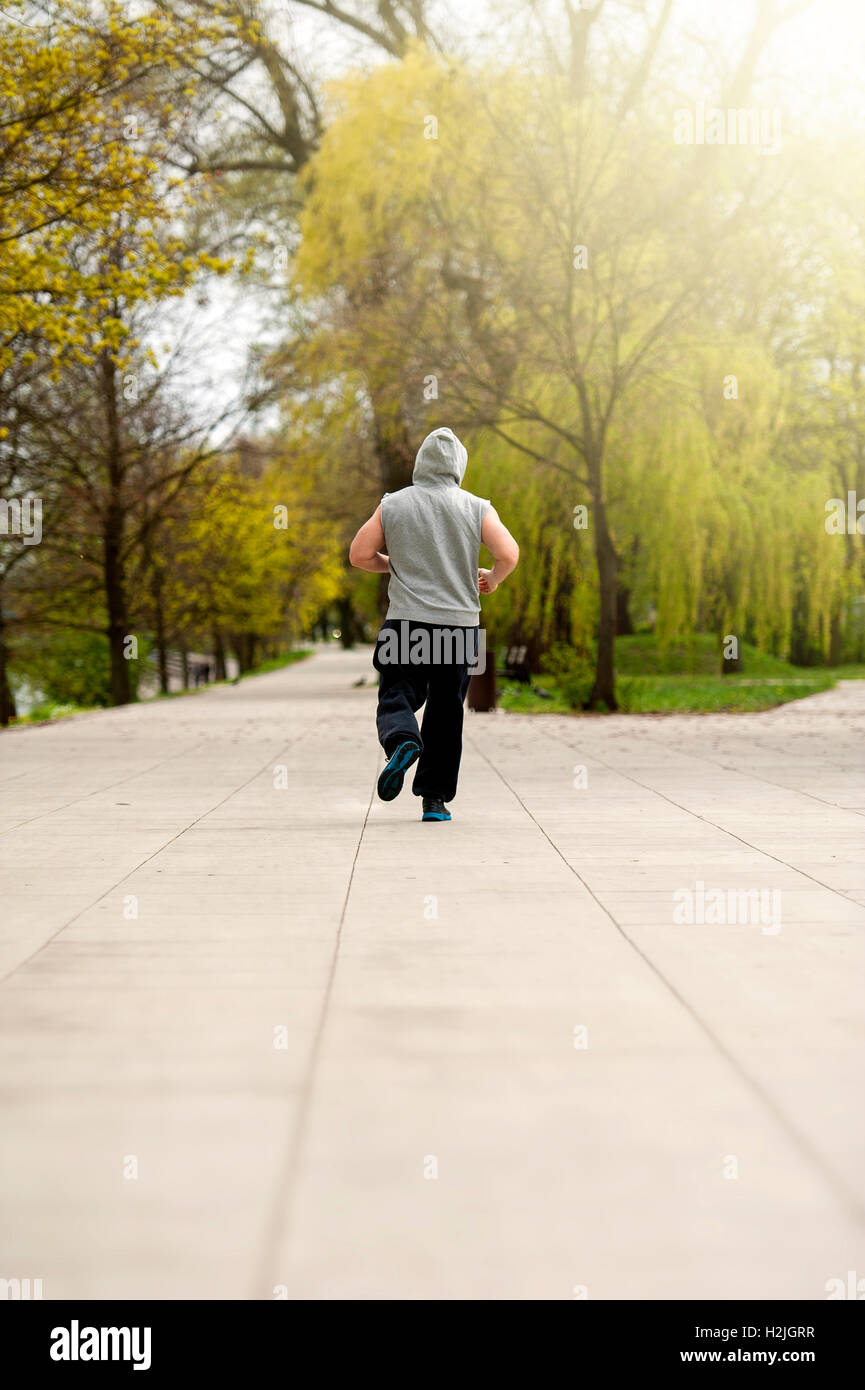 Active man jogger run in park. Back view Stock Photo - Alamy