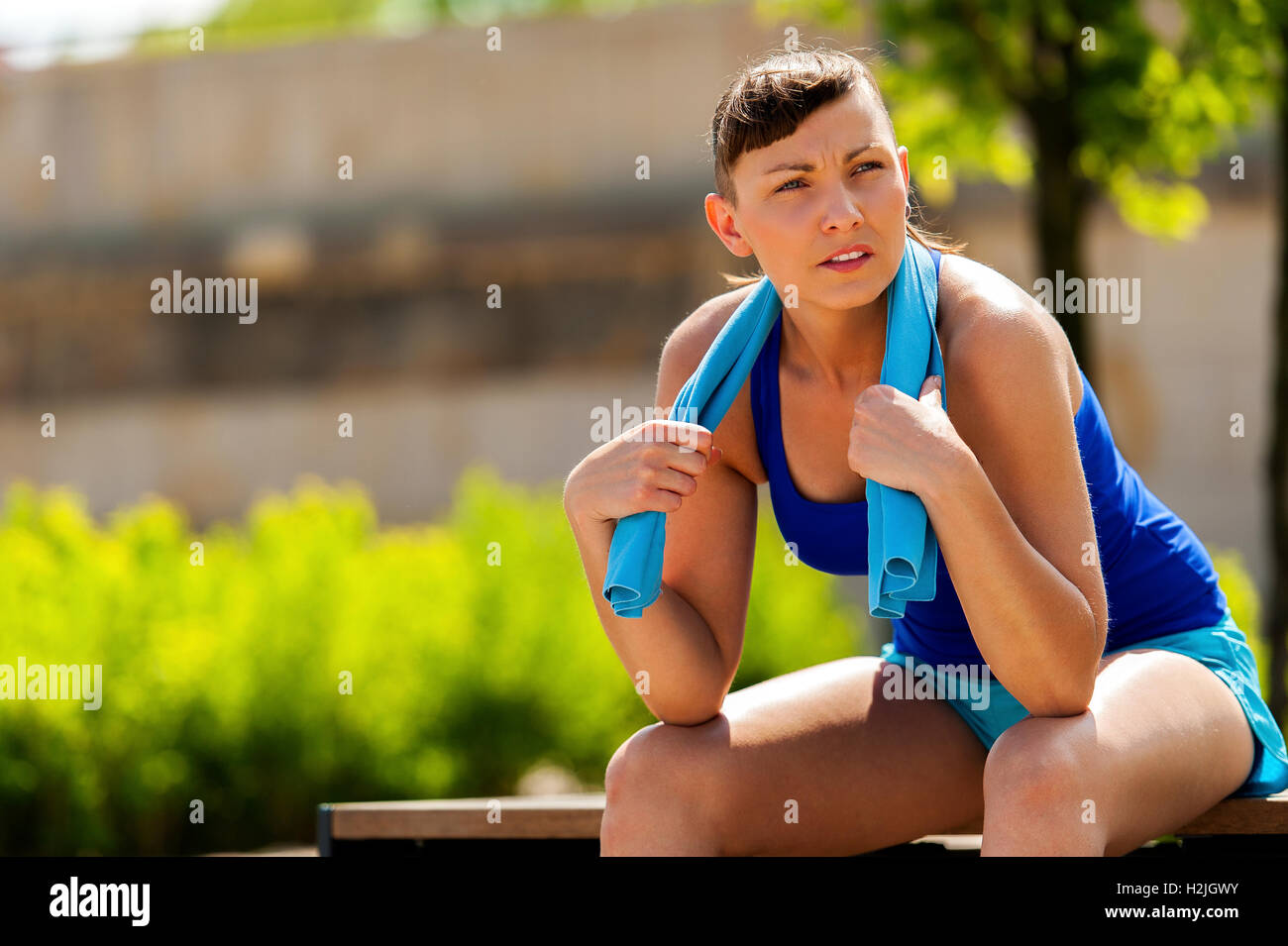 Active woman resting after jogging with towel Stock Photo - Alamy