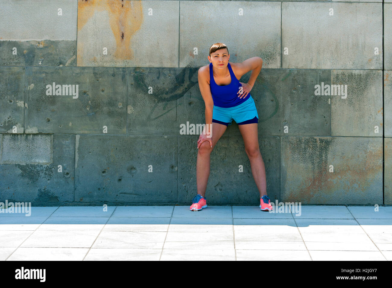 Woman resting after run by the wall. Outdoor Stock Photo - Alamy