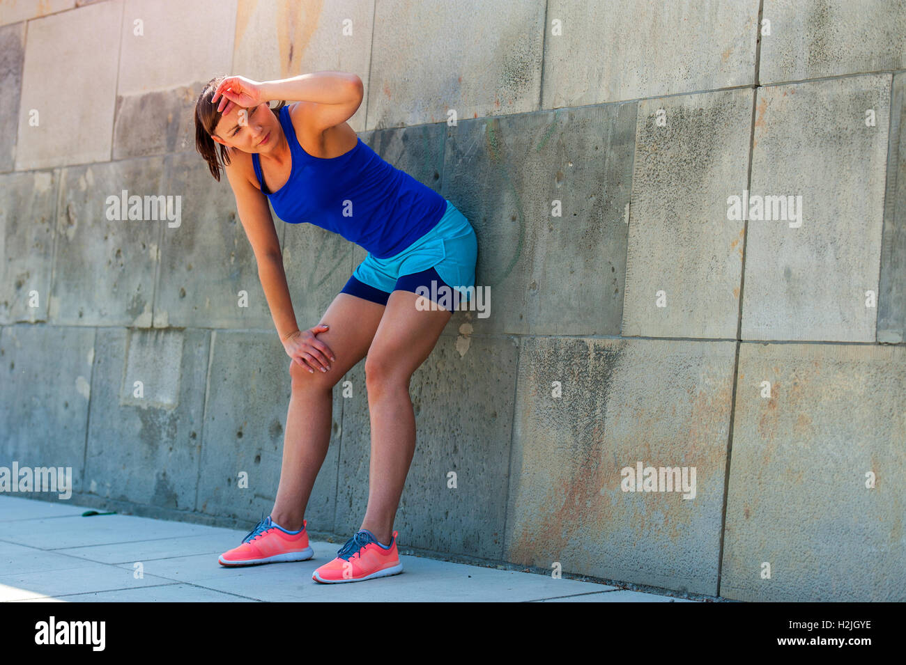 Woman resting after run by the wall. Outdoor Stock Photo - Alamy