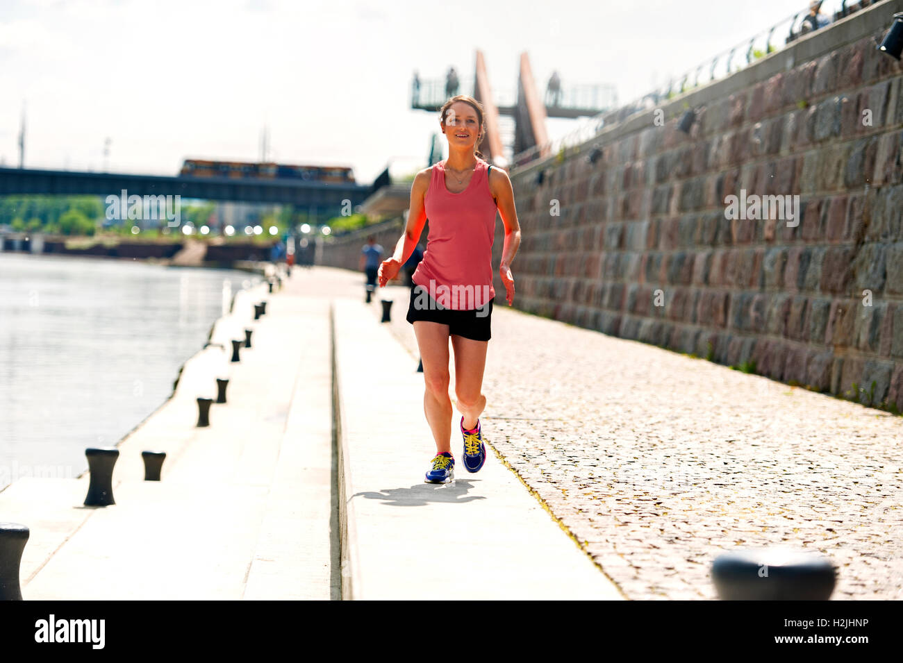 Fit woman jogging by the river Stock Photo - Alamy
