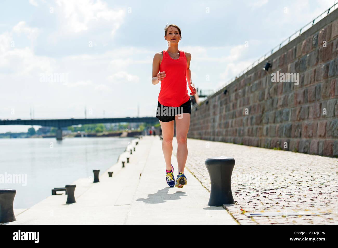 Fit woman jogging by the river Stock Photo - Alamy