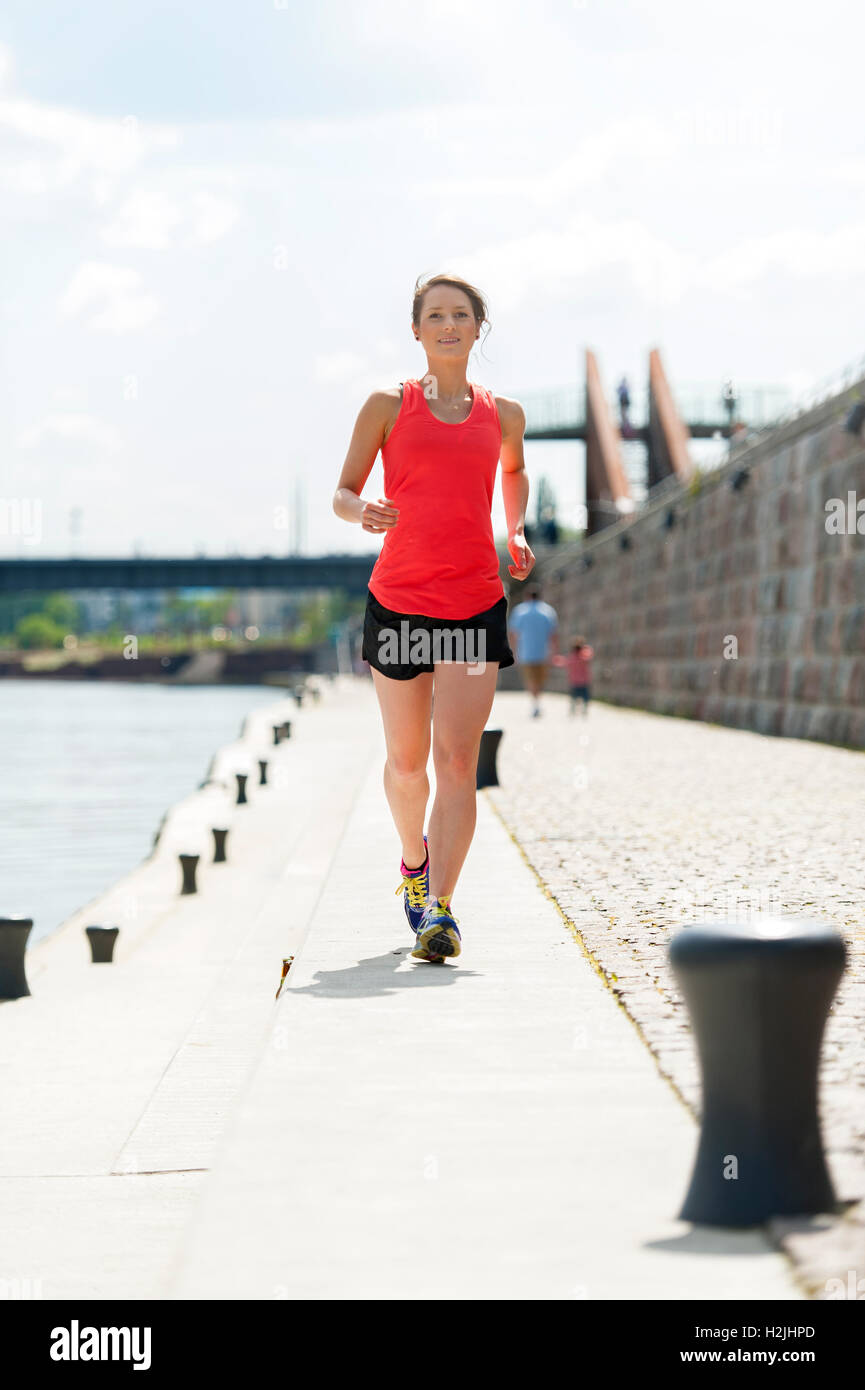 Fit woman jogging by the river Stock Photo - Alamy