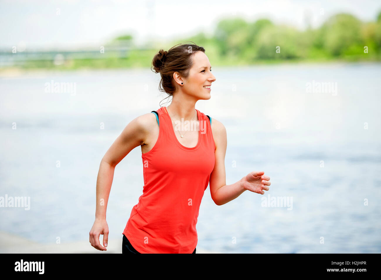 Fit woman jogging by the river Stock Photo - Alamy