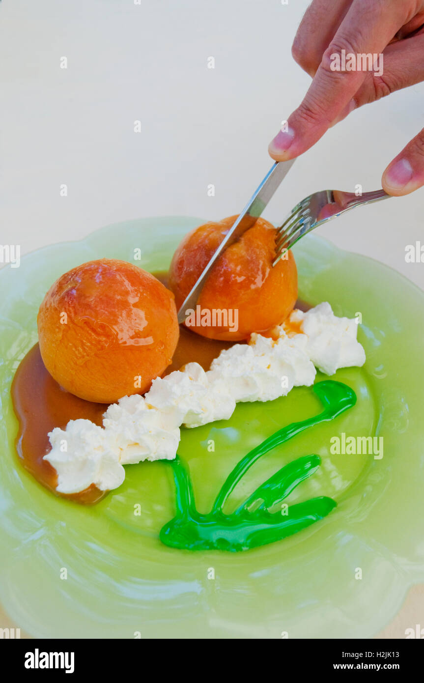 Dessert: Two baked peaches with whipped cream, toffee sauce and ...