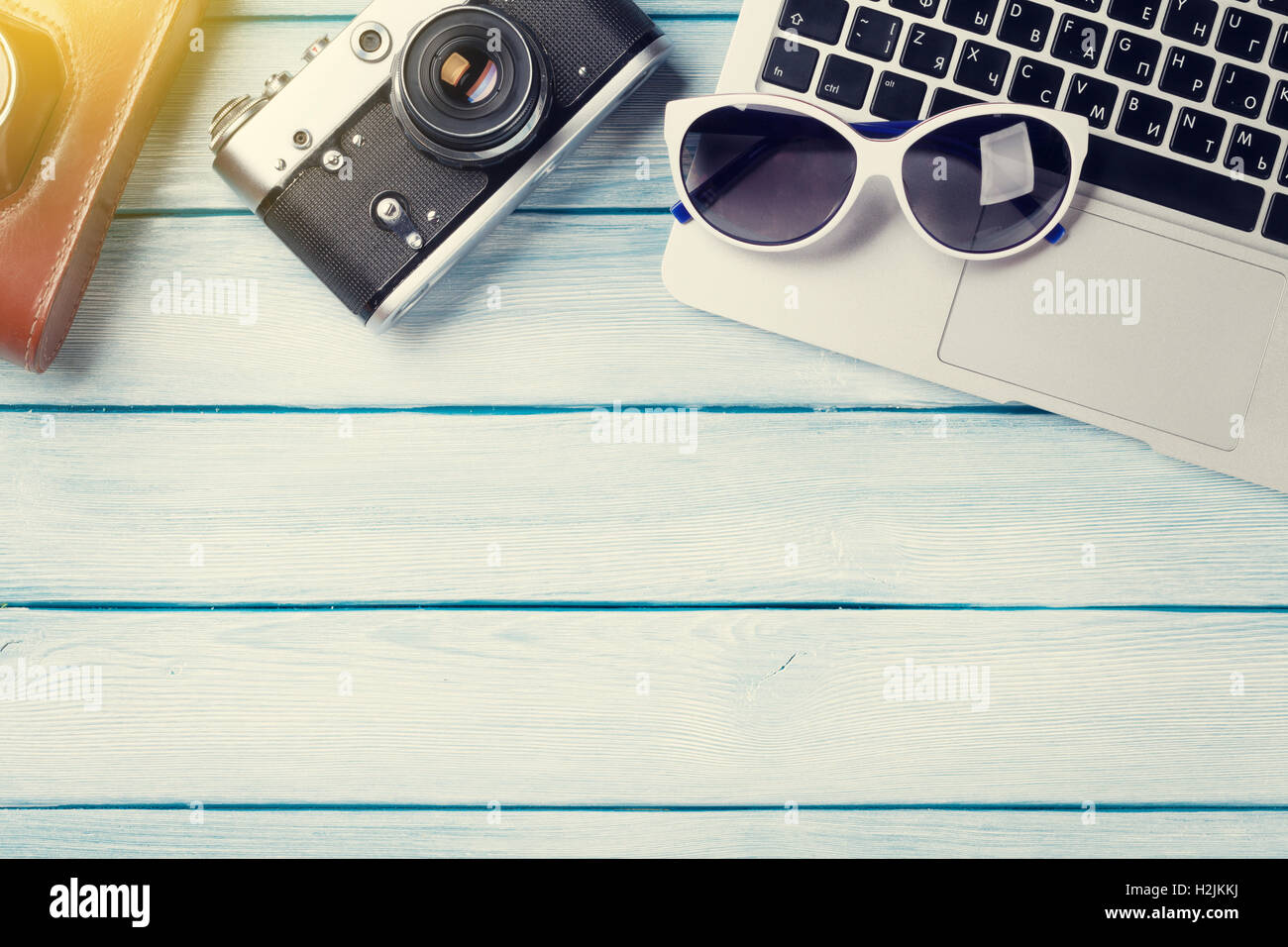 Desk table with laptop and camera on wooden table with sun beam ...