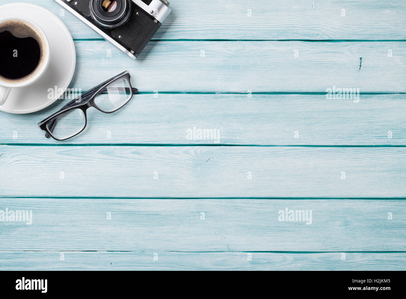 Wooden table with camera, glasses and coffee. Top view with copy space ...