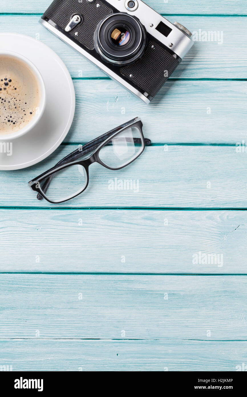Wooden table with camera, glasses and coffee. Top view with copy space ...