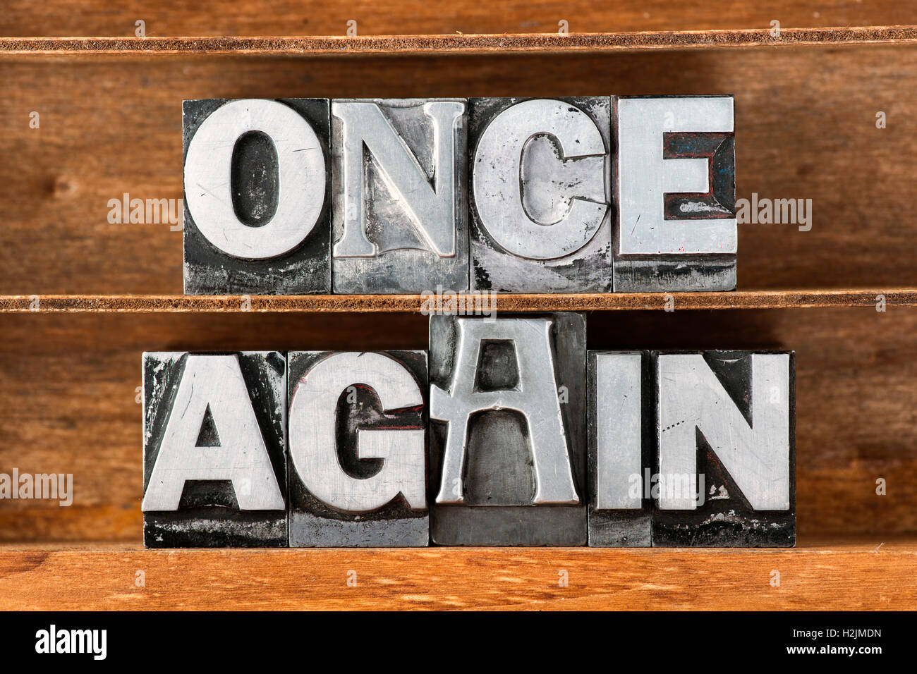 once again phrase made from metallic letterpress type on wooden tray ...