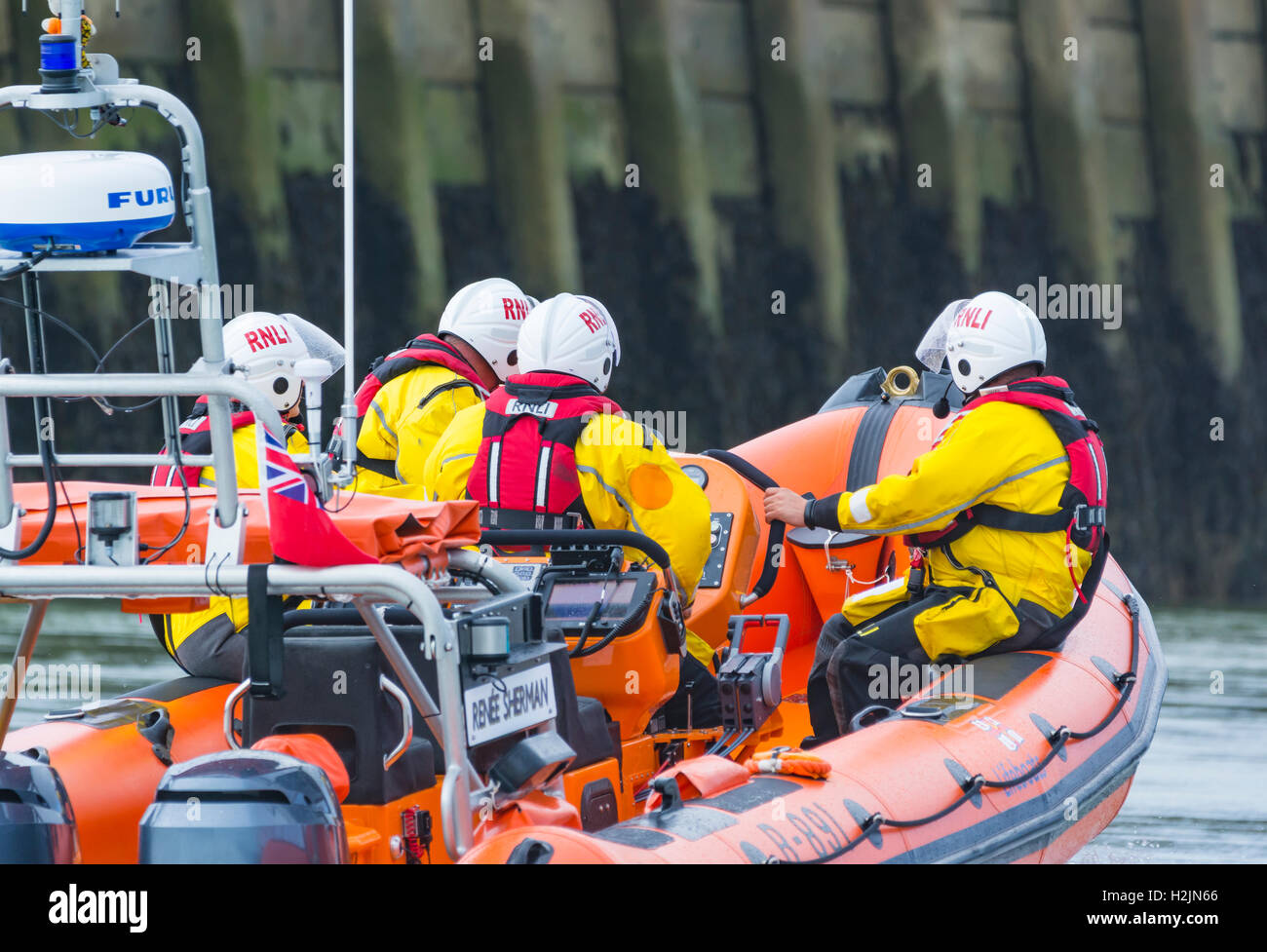 RNLI lifeboat crew on a small lifeboat rib on a river estuary on the ...