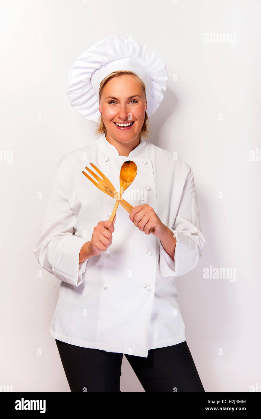 Woman chef with spoon and fork crossed over white background smiling ...