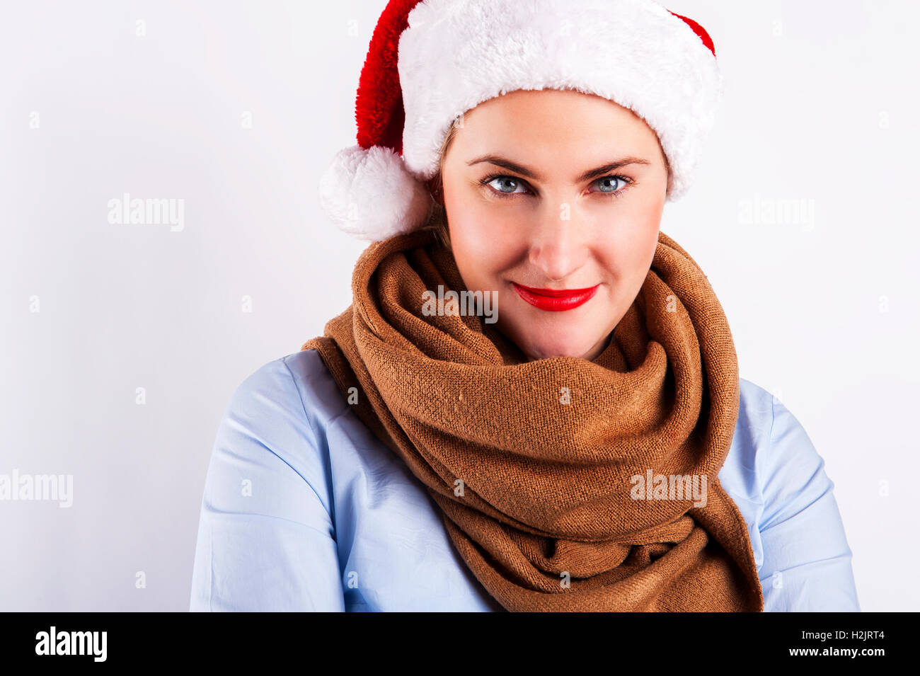 Woman in santa hat blinking one eye. Smiling over white background ...