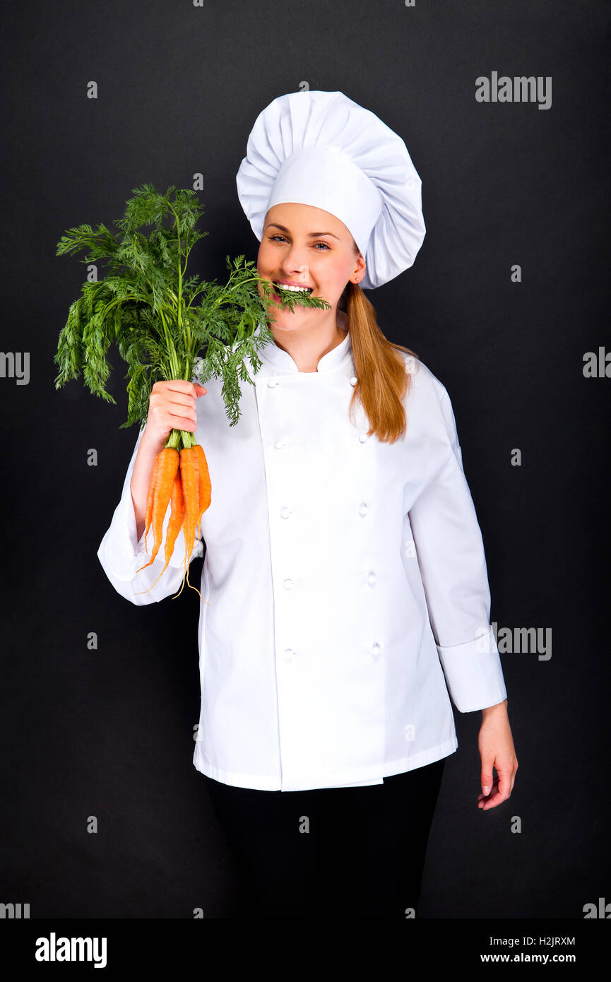female cook in white uniform with bunch of carrots Stock Photo - Alamy