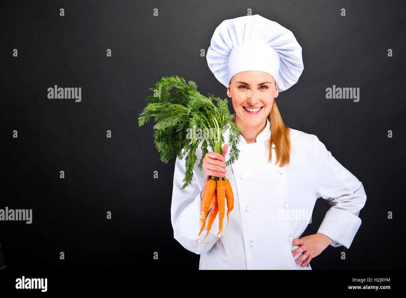 female cook in white uniform with bunch of carrots Stock Photo - Alamy