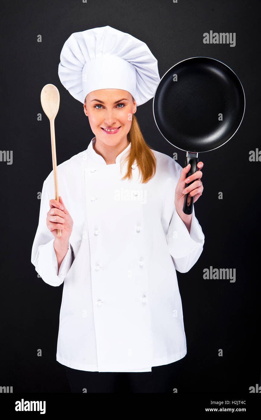 Beautiful blonde woman chef holding pan on white dark background Stock ...