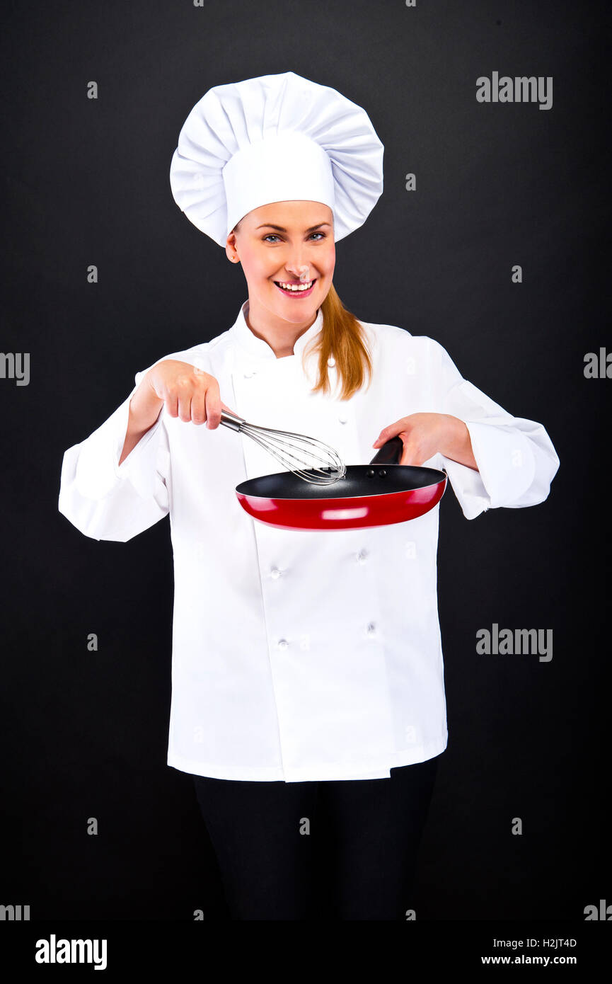 Beautiful blonde woman chef holding pan on white dark background Stock ...