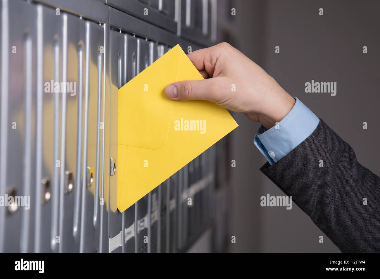 Mailman putting the letter into the mailbox Stock Photo - Alamy