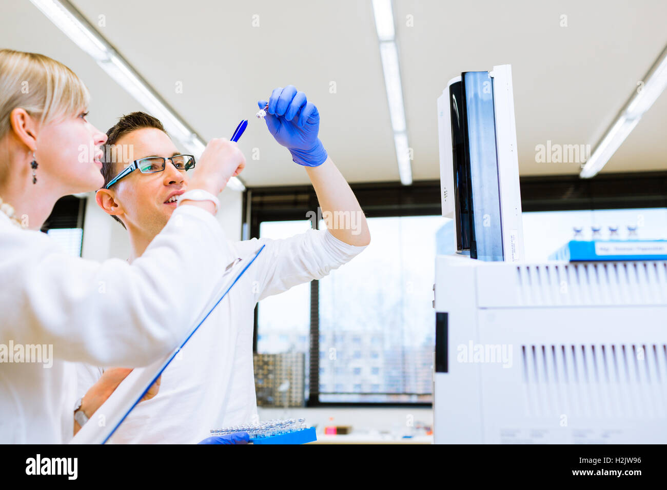 Two young researchers carrying out experiments in a lab Stock Photo - Alamy