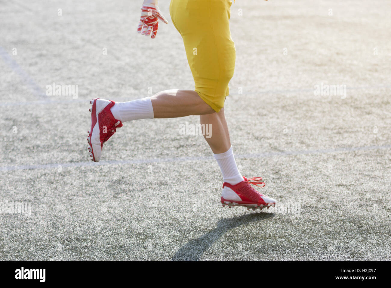 Unrecognizable football player running on the green grass court Stock ...