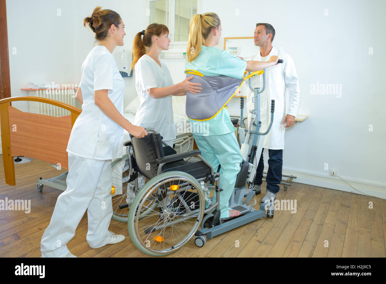 Medical staff helping woman to standing Stock Photo - Alamy