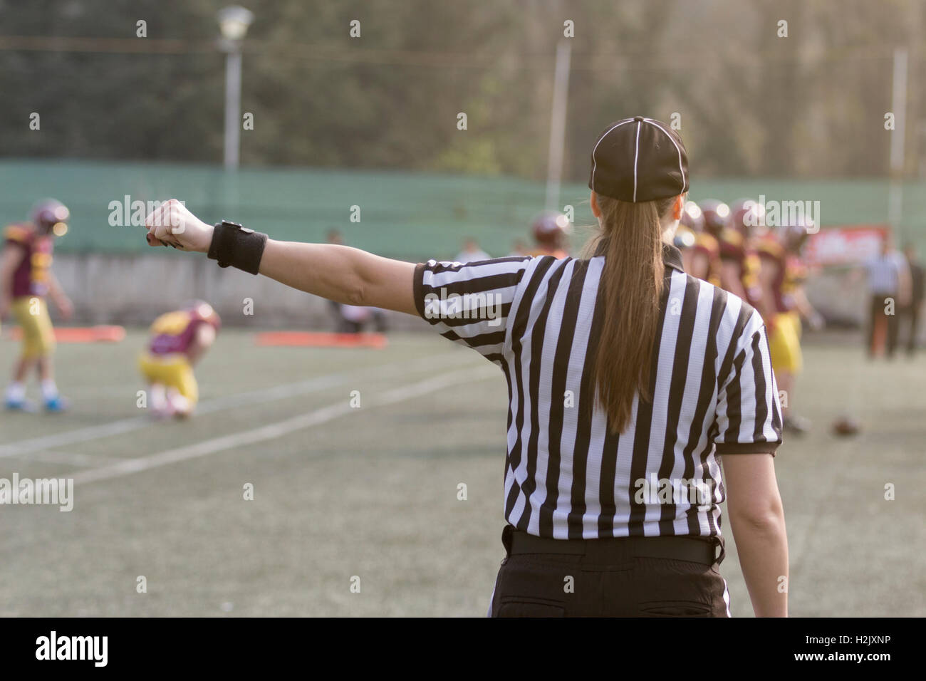 Female football judge in stripped black and white shirts on the field ...