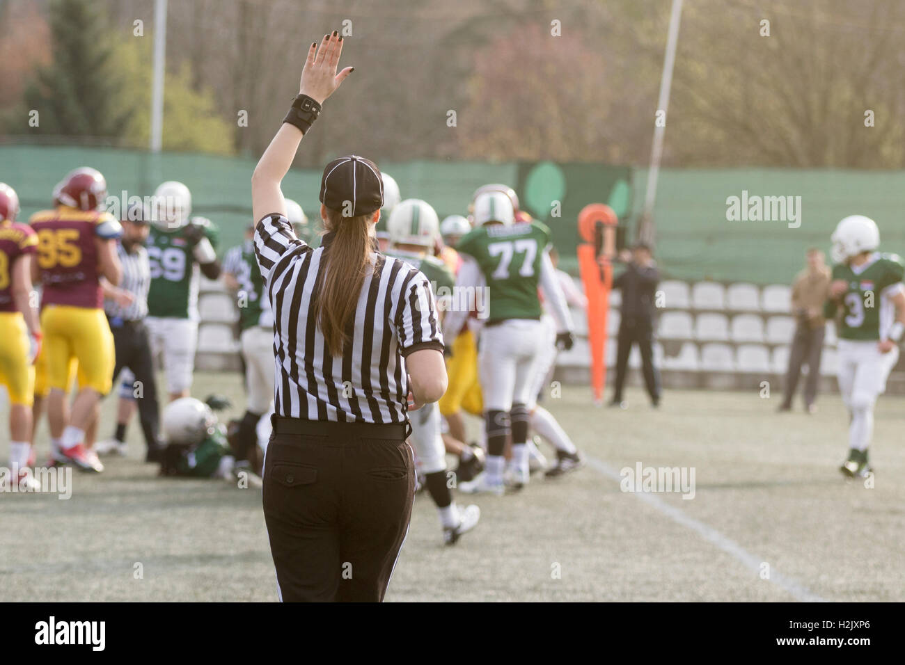 : Female football judge in stripped black and white shirts on the field ...