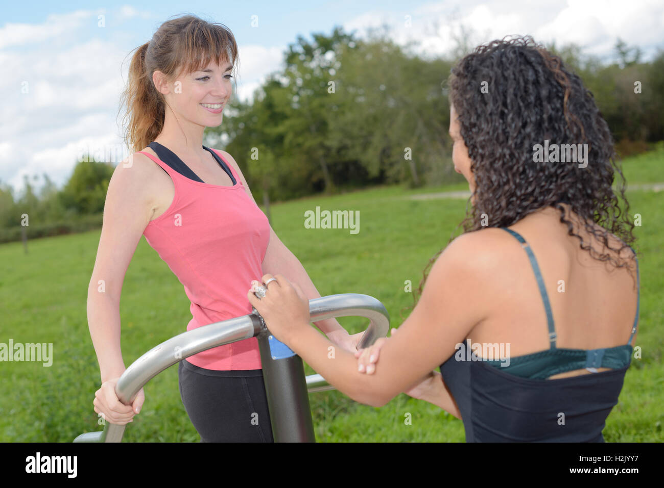 Woman twisting on outdoor fitness equipment Stock Photo - Alamy