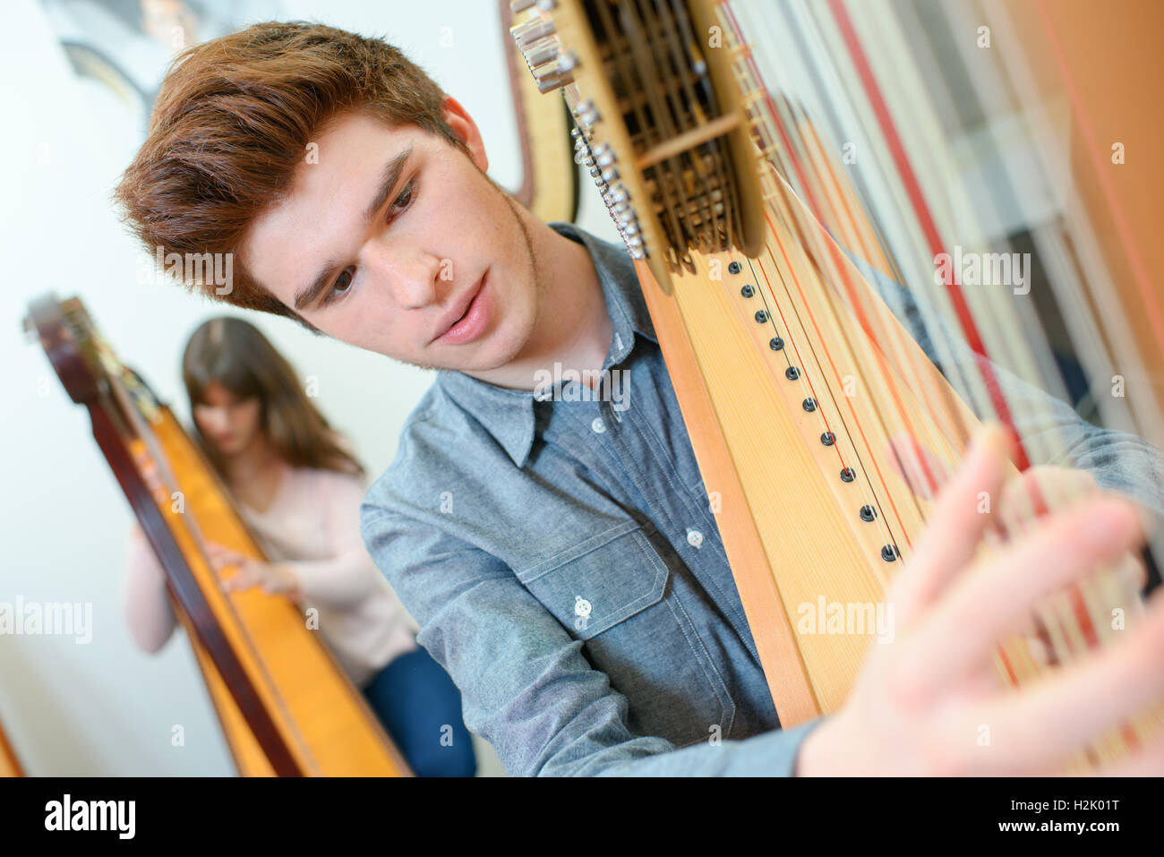 Teenager playing the harp Stock Photo - Alamy