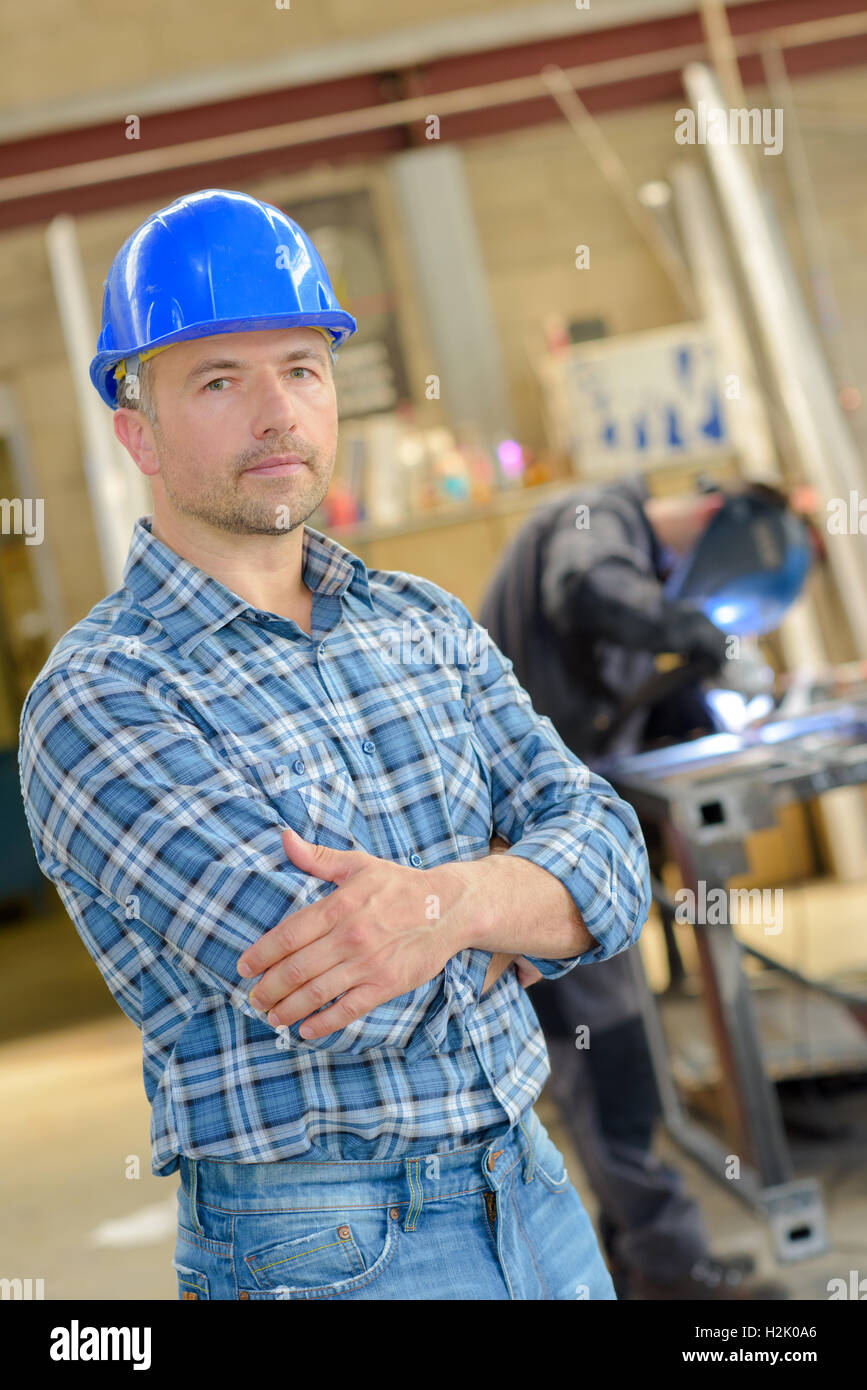 Portrait of workman, arms crossed Stock Photo - Alamy