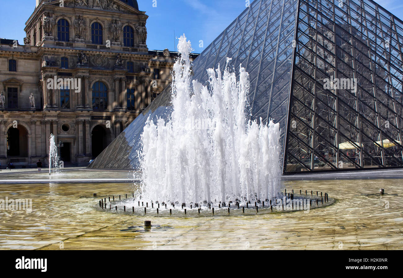 Water fountain by famous glass pyramid at the courtyard of Louvre ...