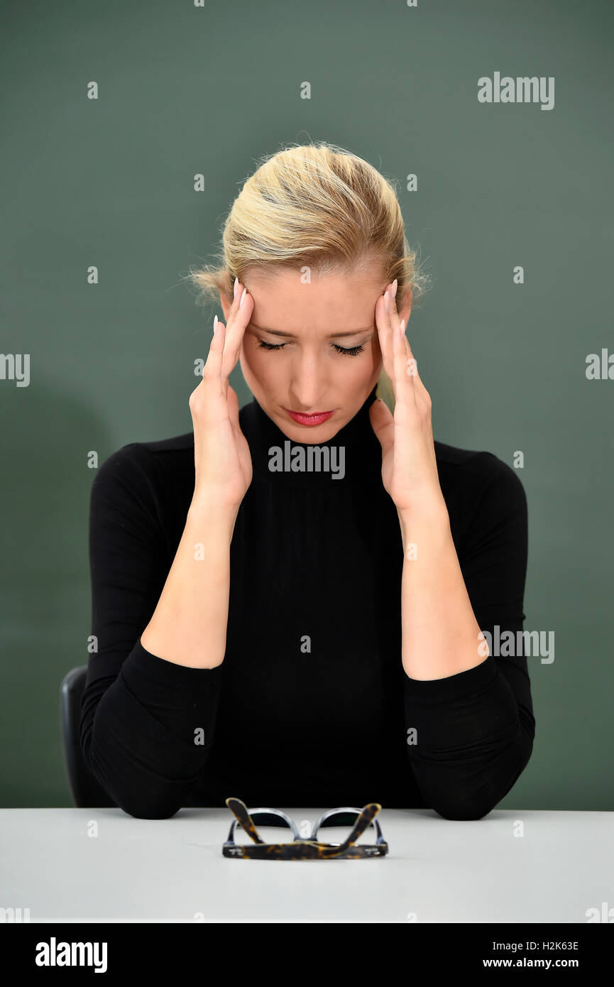 Stressed, thoughtful teacher, tutor, trainer, in front of a blackboard ...