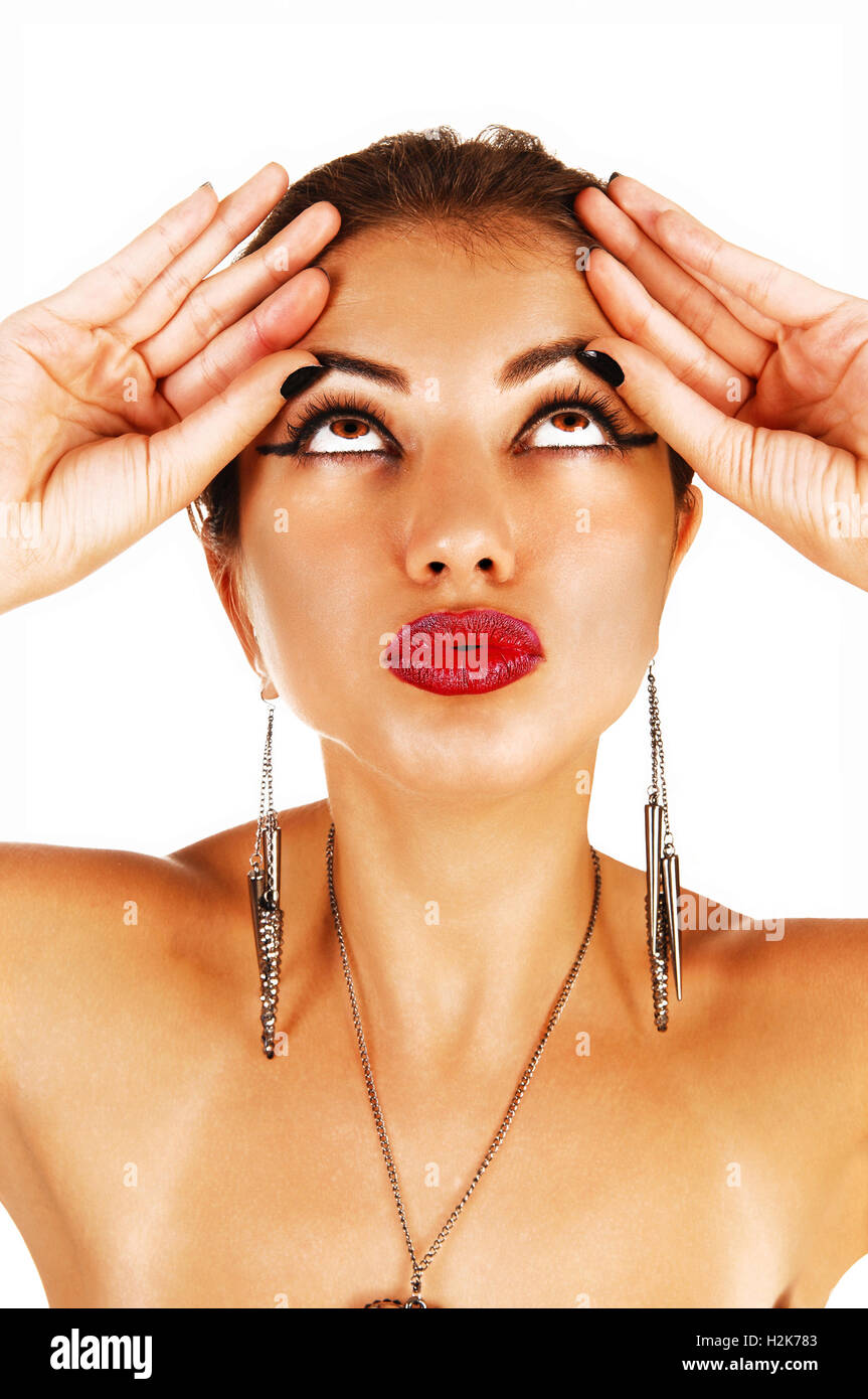 A gorgeous young woman with both hands on her forehead and looking up ...