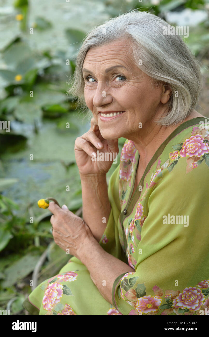 Elderly woman near lake Stock Photo - Alamy