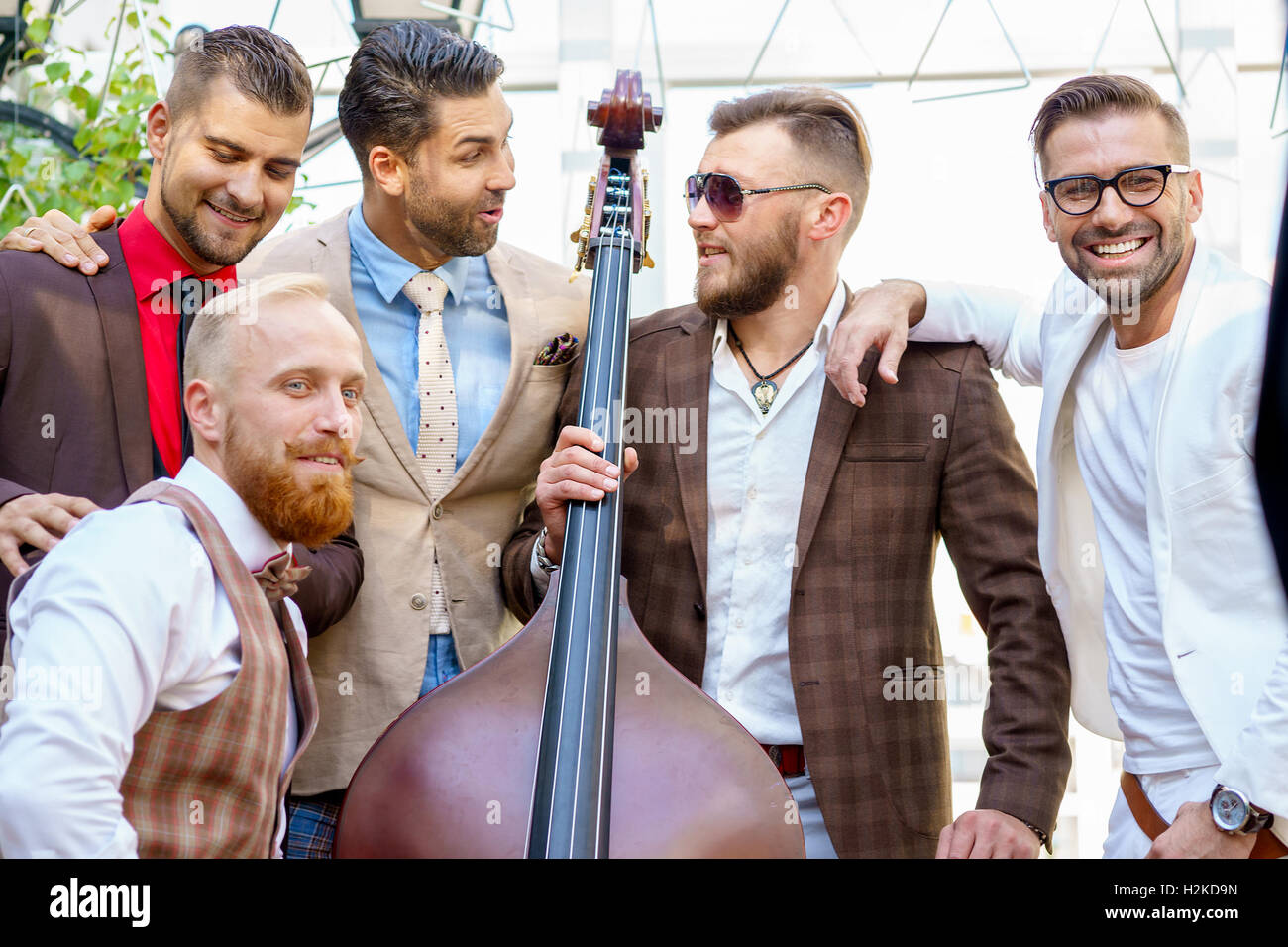 Group of five stylish male friends talking and having fun outdoors ...