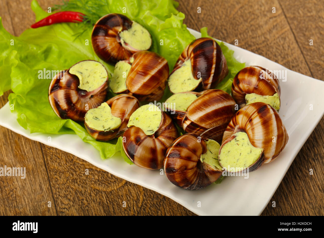 Escargot with cheese cream on salad leaves Stock Photo - Alamy