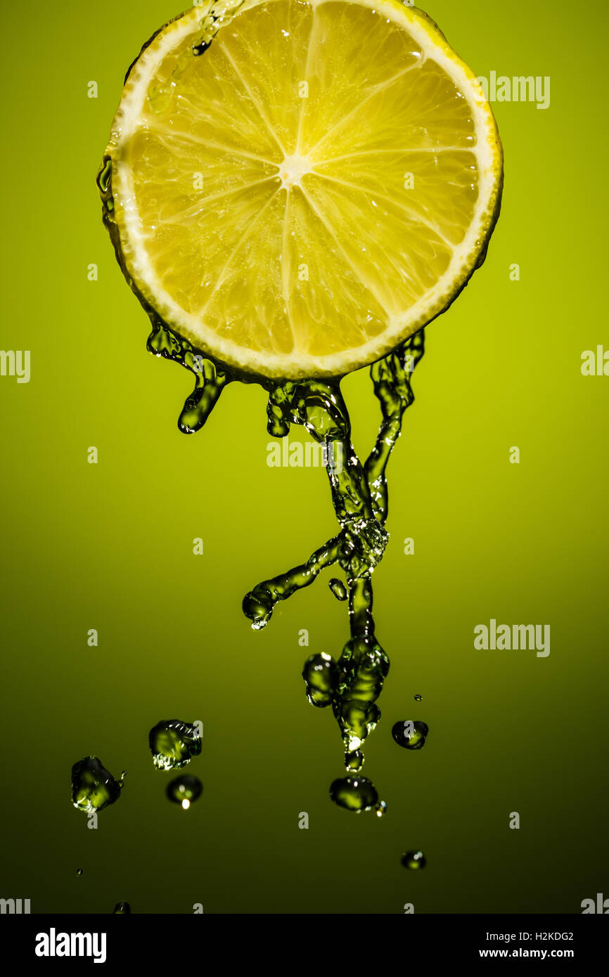 Drops of lime juice falling down. Colorful background Stock Photo - Alamy