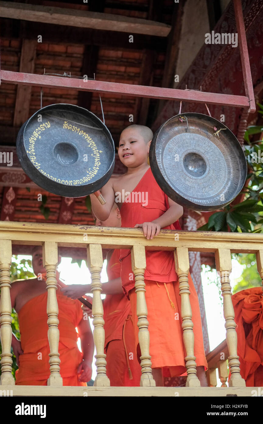 Novice Monk Sounding a gong Louang Prabang Loas Stock Photo - Alamy