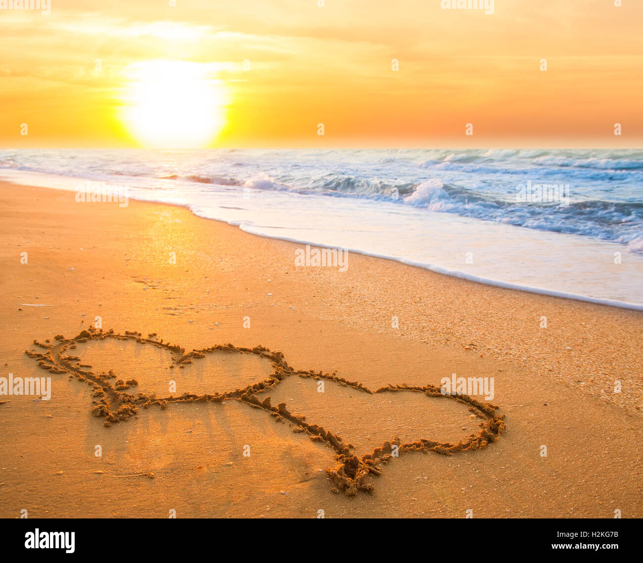 two hand drawn hearts on beach sand over sunset Stock Photo - Alamy