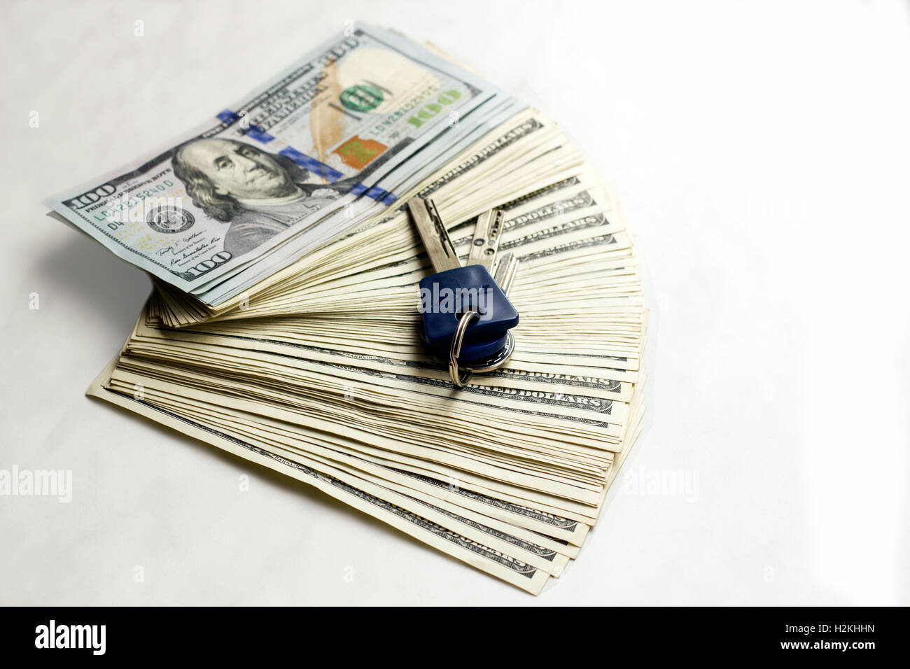 Stack of new hundred-dollar banknotes with keys. Earning income money ...