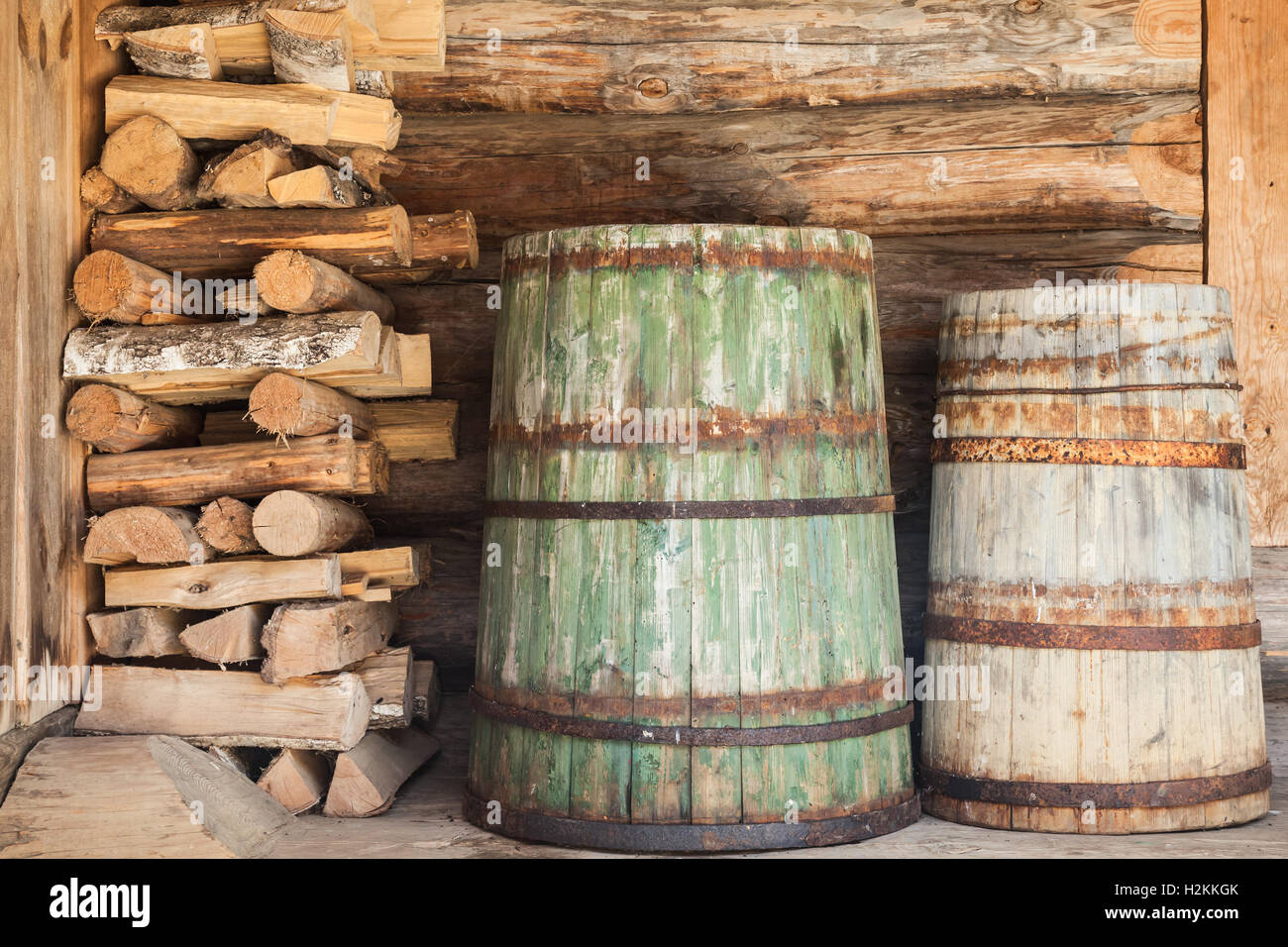 Old wooden barrels and stack of firewood, vintage Russian rural objects ...