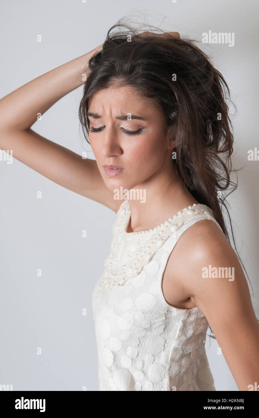 Beautiful young woman hands on head Stock Photo - Alamy