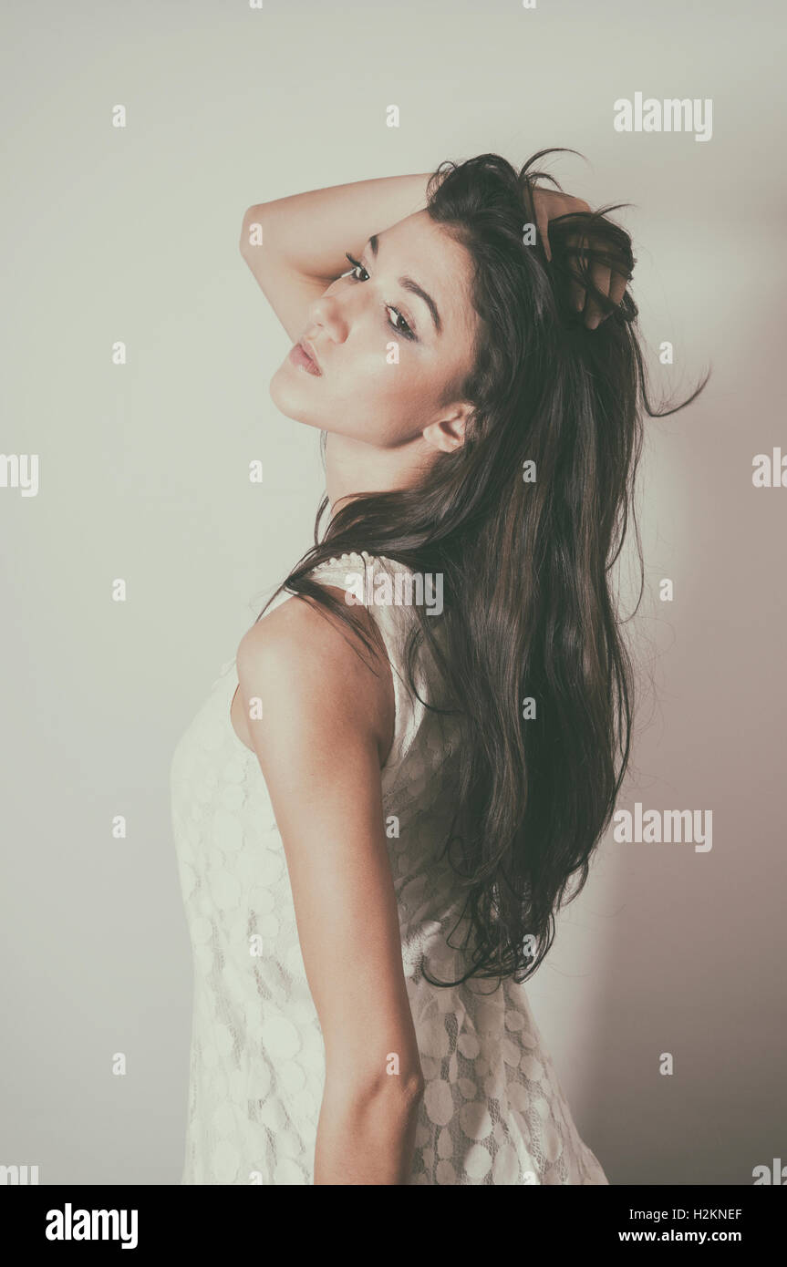 Beautiful young woman hand over head looking away Stock Photo - Alamy