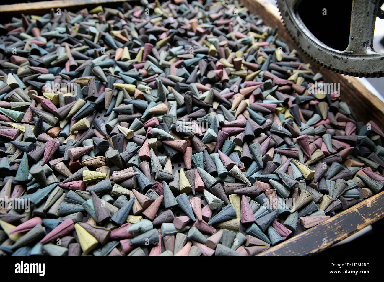 Different incense candles lie in a case next to a press in the sales ...