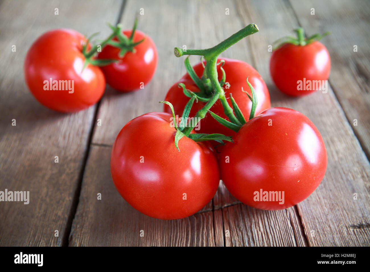 Sweet red tomato isolated on brown wooden background Stock Photo - Alamy
