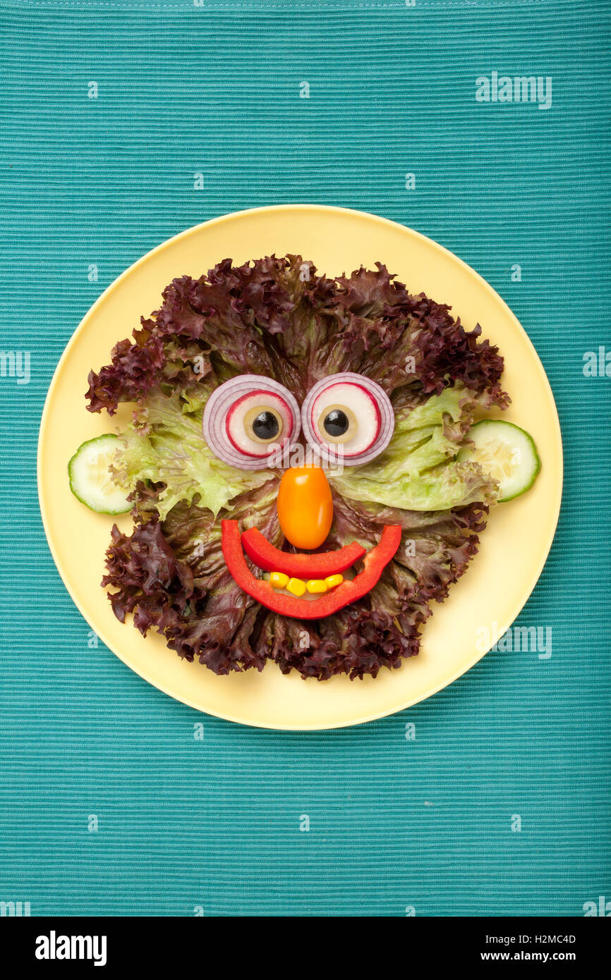 Funny smiling face made of vegetables on plate and fabric Stock Photo ...