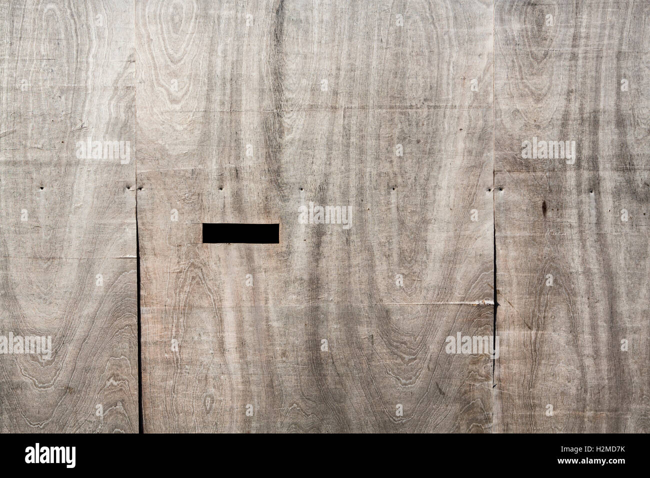 Small letter box size hole cut into a wall of wood panelling Stock ...
