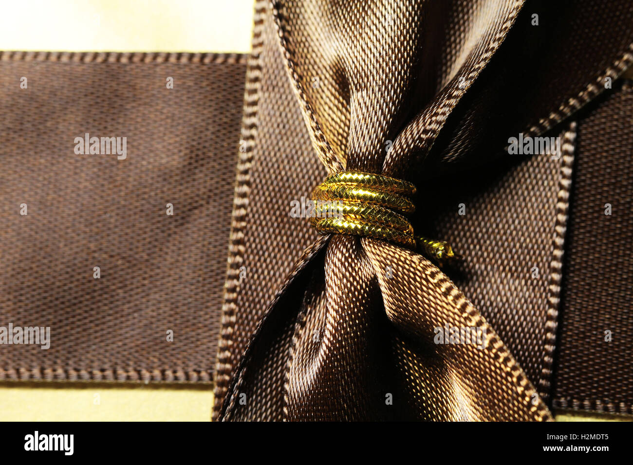 Gift box of golden color with brown ribbon Stock Photo - Alamy