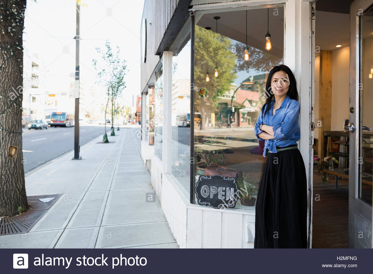 Portrait confident female shop owner in storefront doorway Stock Photo ...