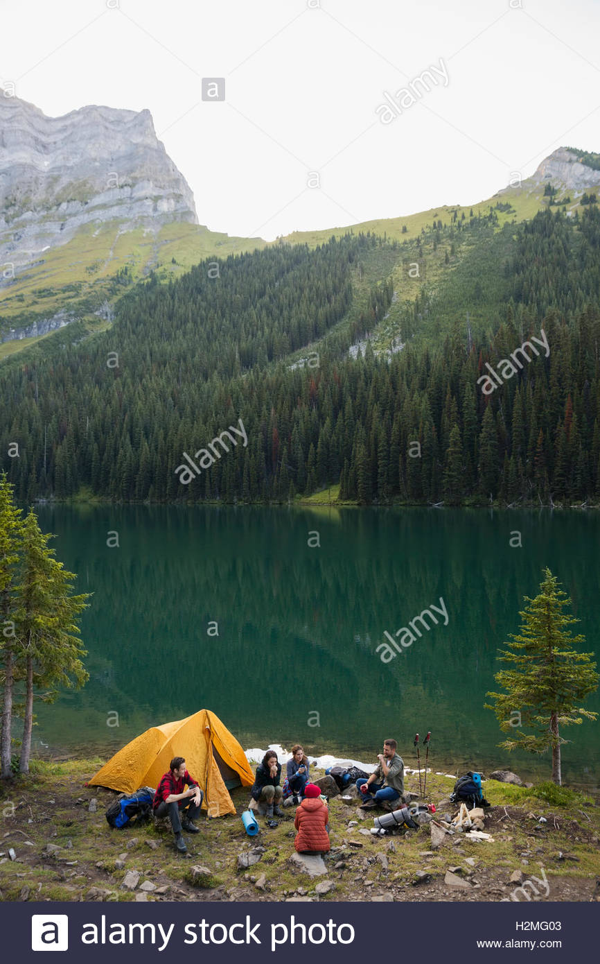 Friends camping at remote lakeside campsite Stock Photo - Alamy