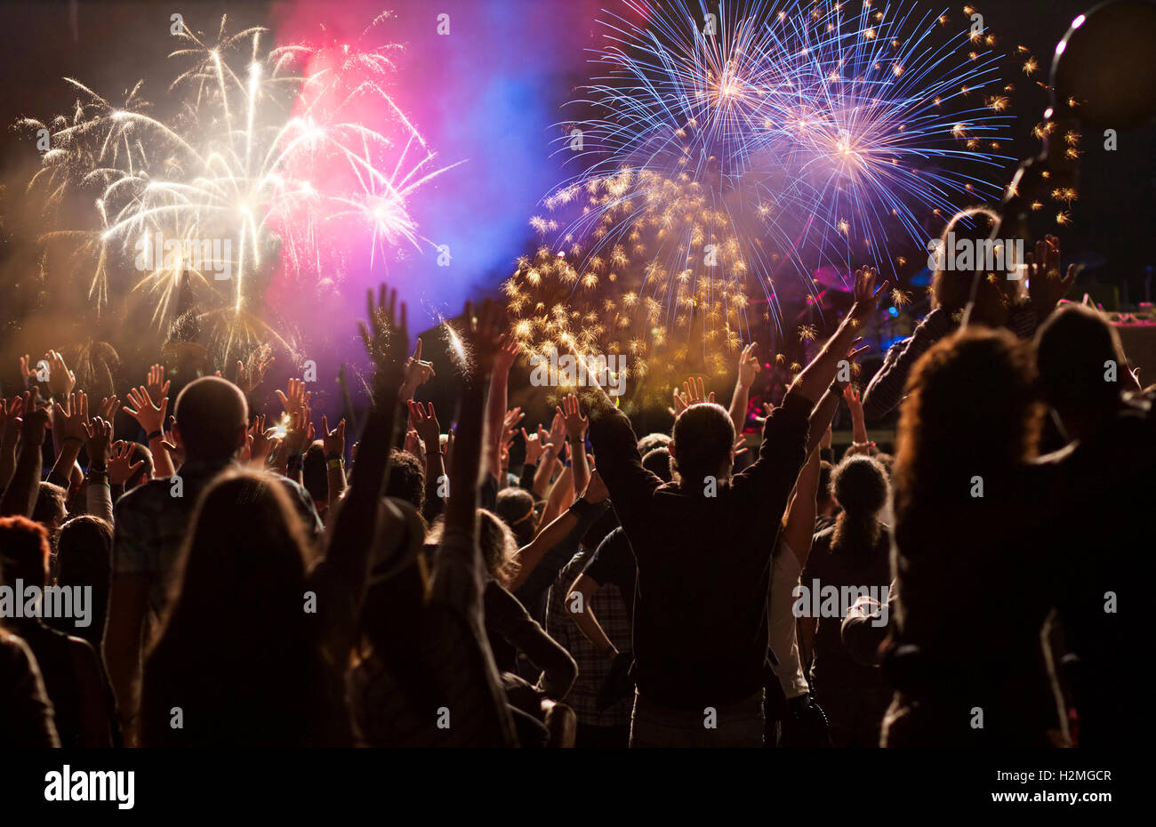 New Year concept - cheering crowd and fireworks Stock Photo - Alamy
